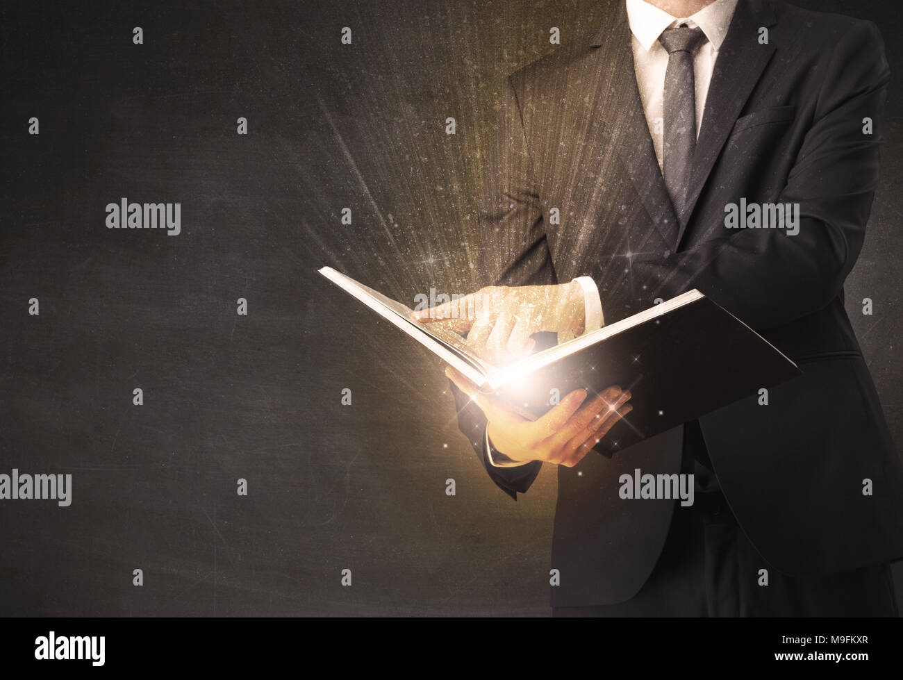 Man holding and reading a shiny book Stock Photo - Alamy