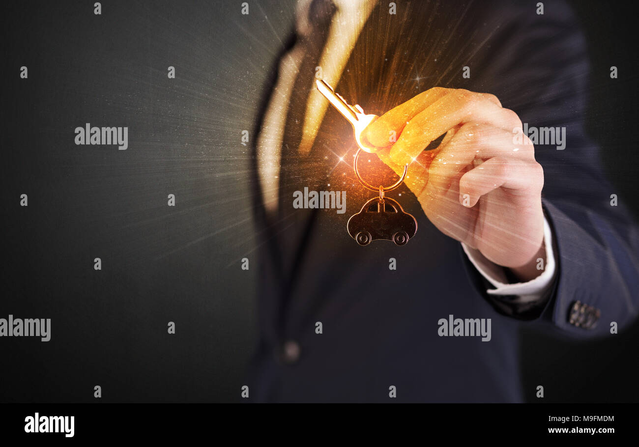 Formal man hand over shiny keys with dark background Stock Photo - Alamy