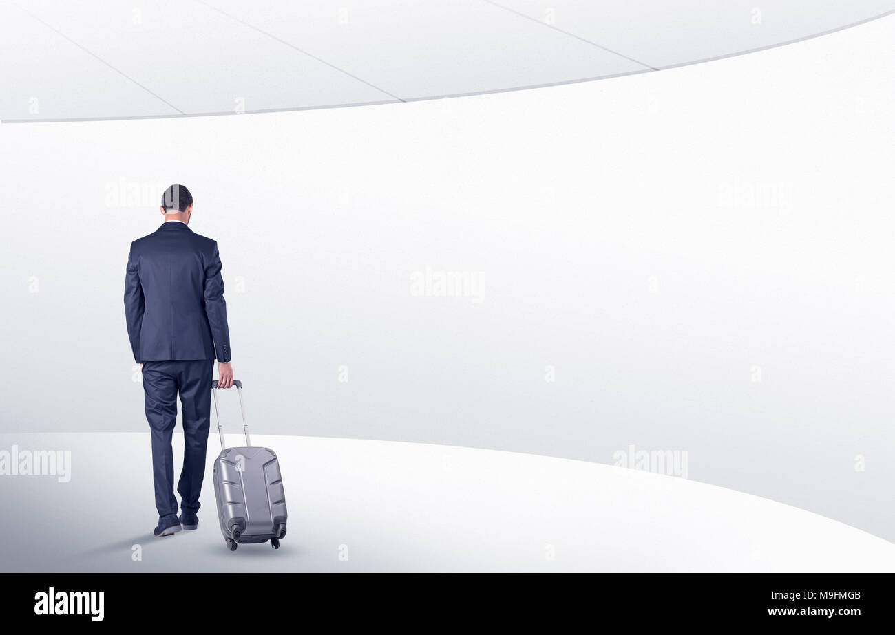 Businessman with back walking in a white waiting room with empty walls ...
