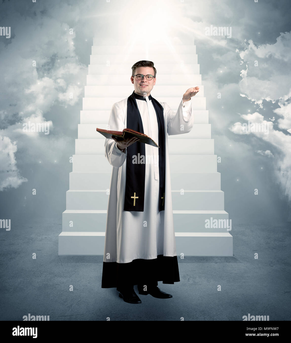 A young religious happy priest standing in front of the stairway to ...