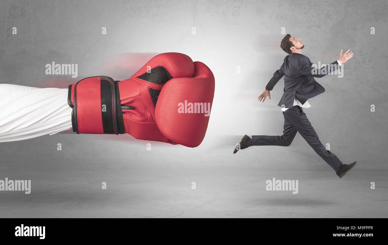 Businessman gets a hit from a giant hand with boxing gloves Stock Photo ...
