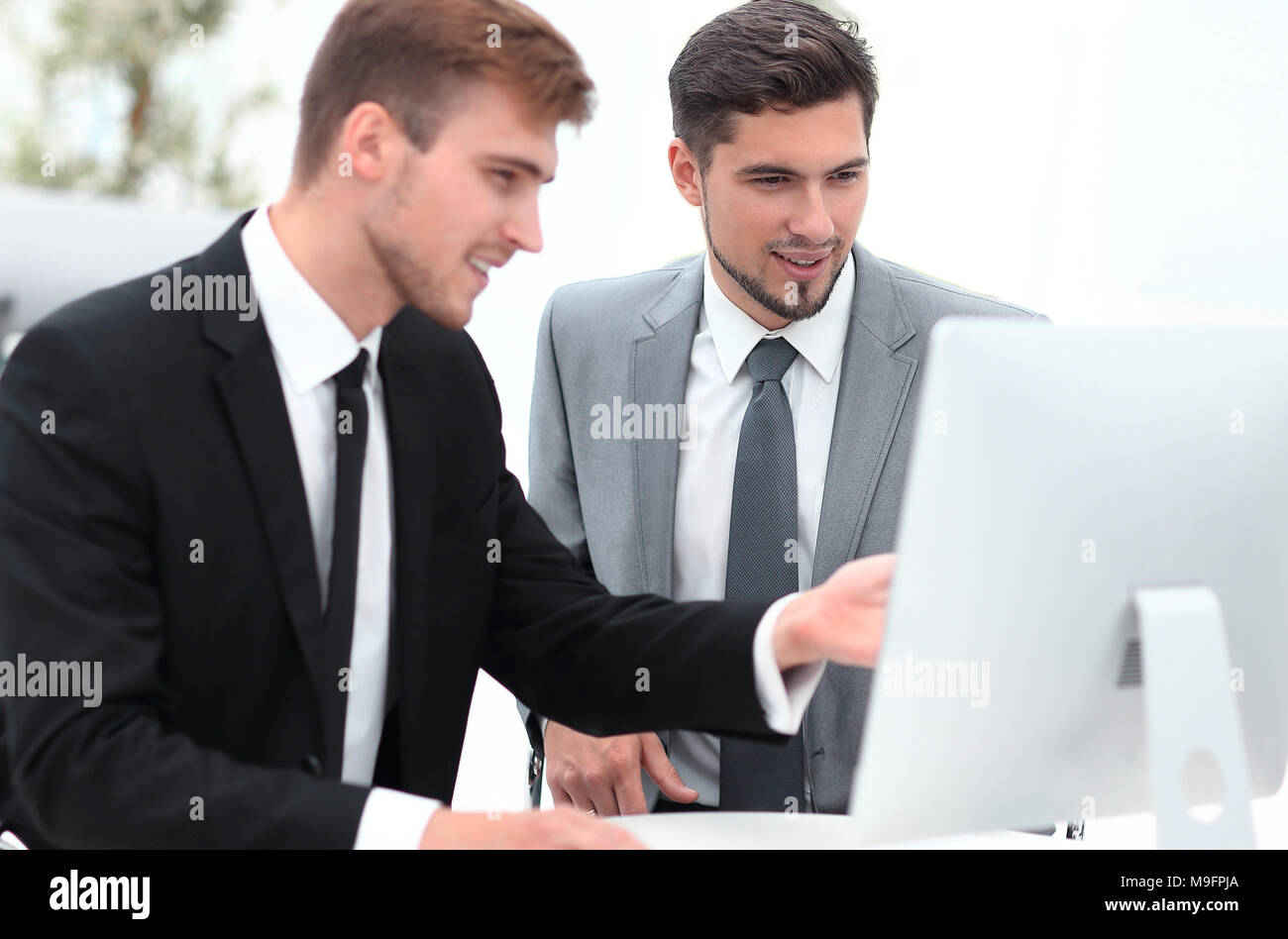 employees are talking sitting behind a Desk Stock Photo - Alamy