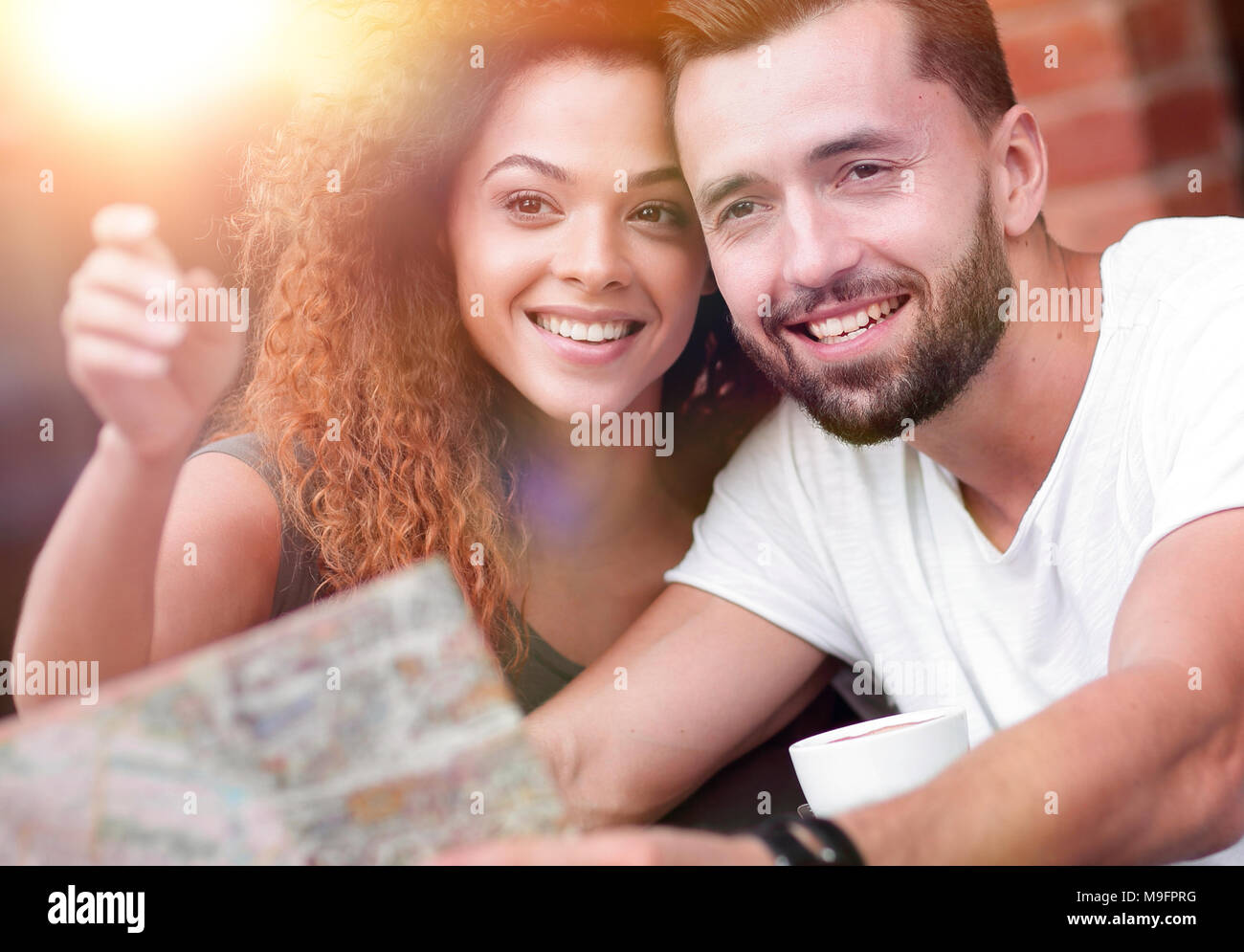 Young tourists having coffee at cafe and reading map Stock Photo - Alamy