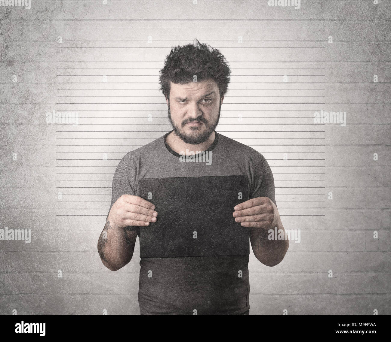 Gangster in front of a wall with table on his hand Stock Photo - Alamy