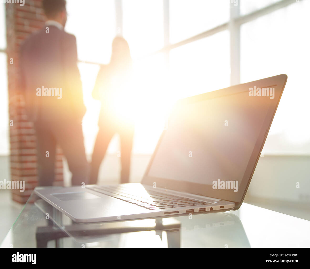 Glass desktop with laptop and other items in modern office. Workplace ...