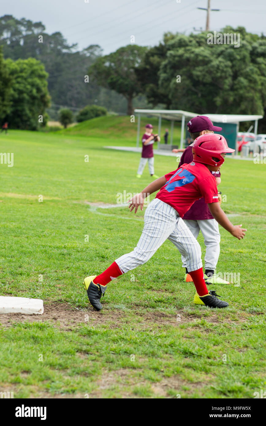 A junior softball player on third base ready to stretched and ready to ...