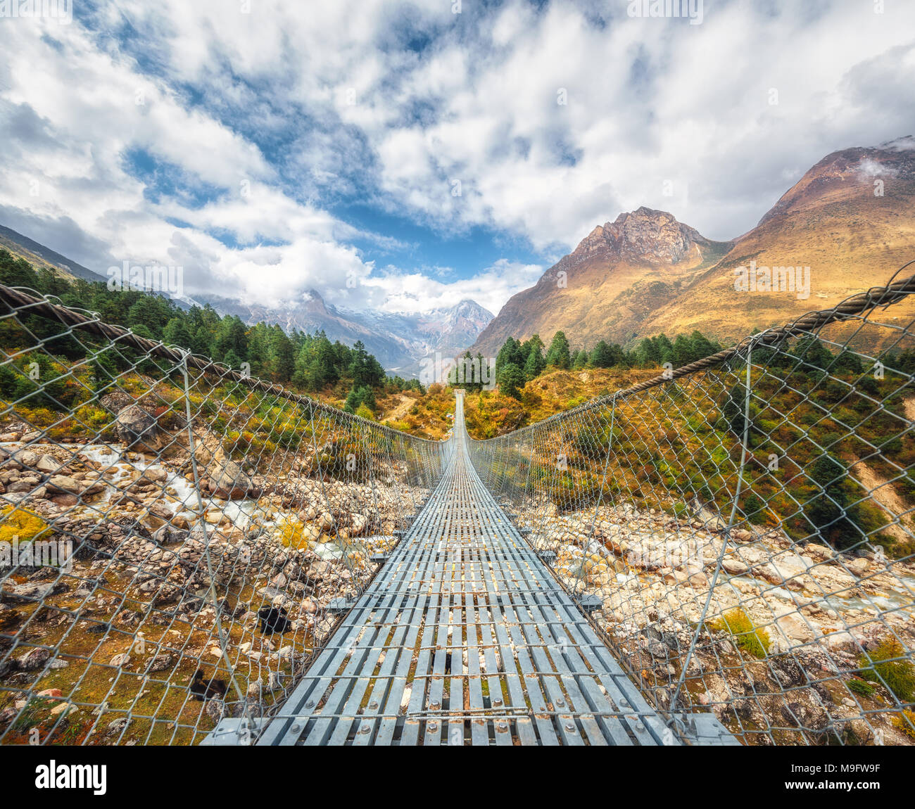 Suspension bridge and beautiful himalayan mountains at sunset in summer ...