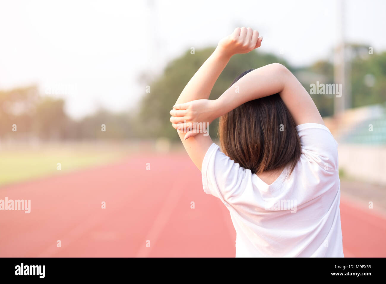Young woman stretching her arms before running on ruuning track Stock ...
