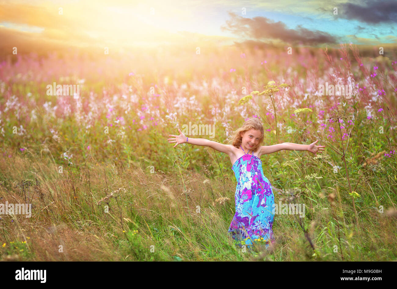 joyful dancing girl in a field of flowers Stock Photo - Alamy