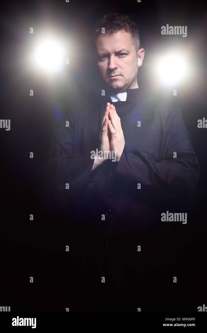 praying priest on black background Stock Photo - Alamy