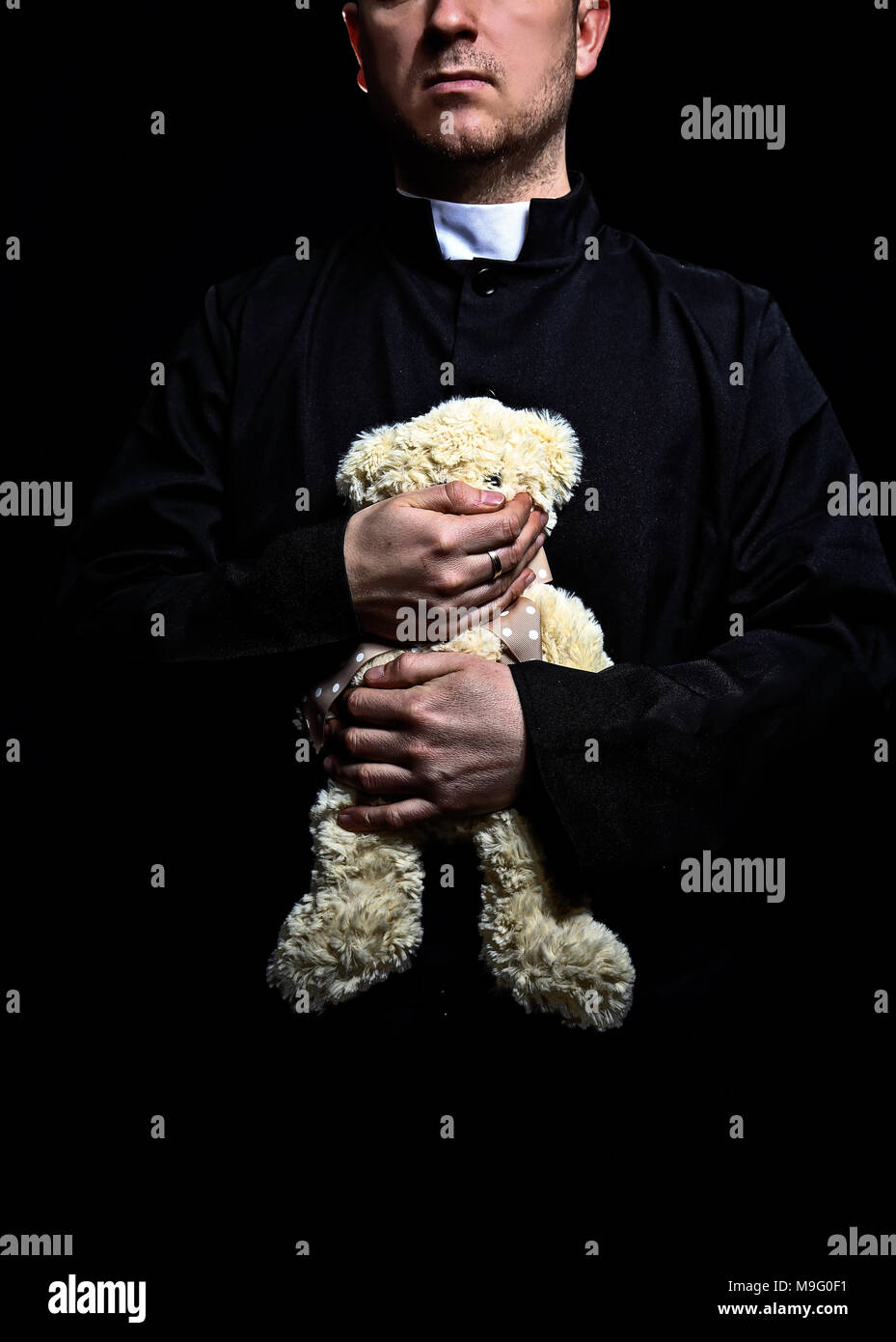 priest holding a teddy bear Stock Photo - Alamy