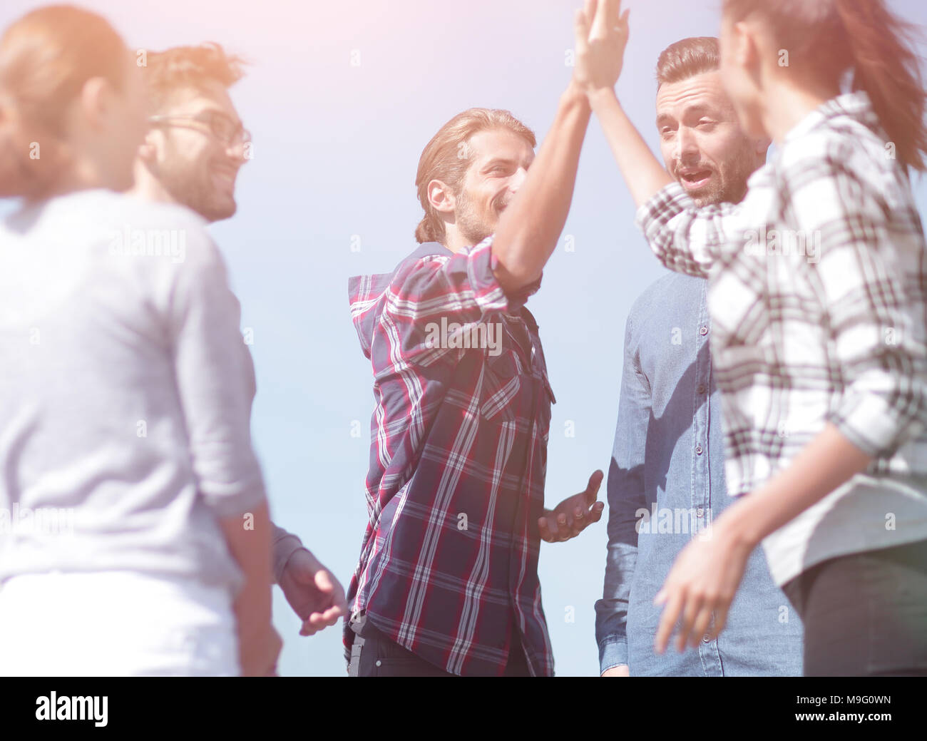 friends greet each other, giving a high five Stock Photo - Alamy