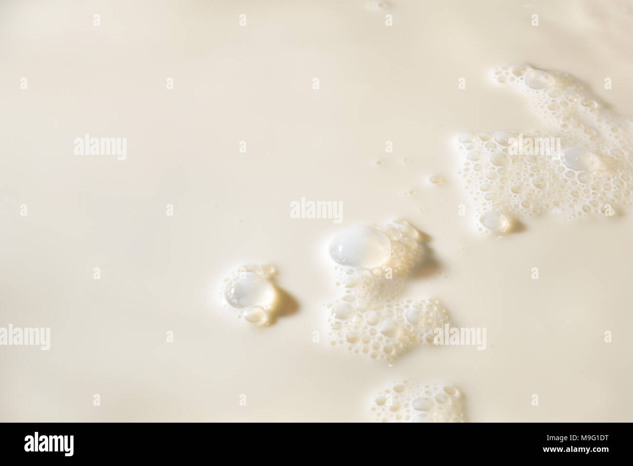Milk texture background with foam and bubbles on the surface close up ...