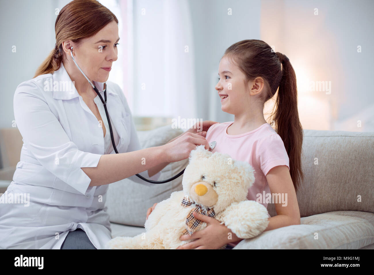 Skillful female doctor checking heart beat Stock Photo - Alamy