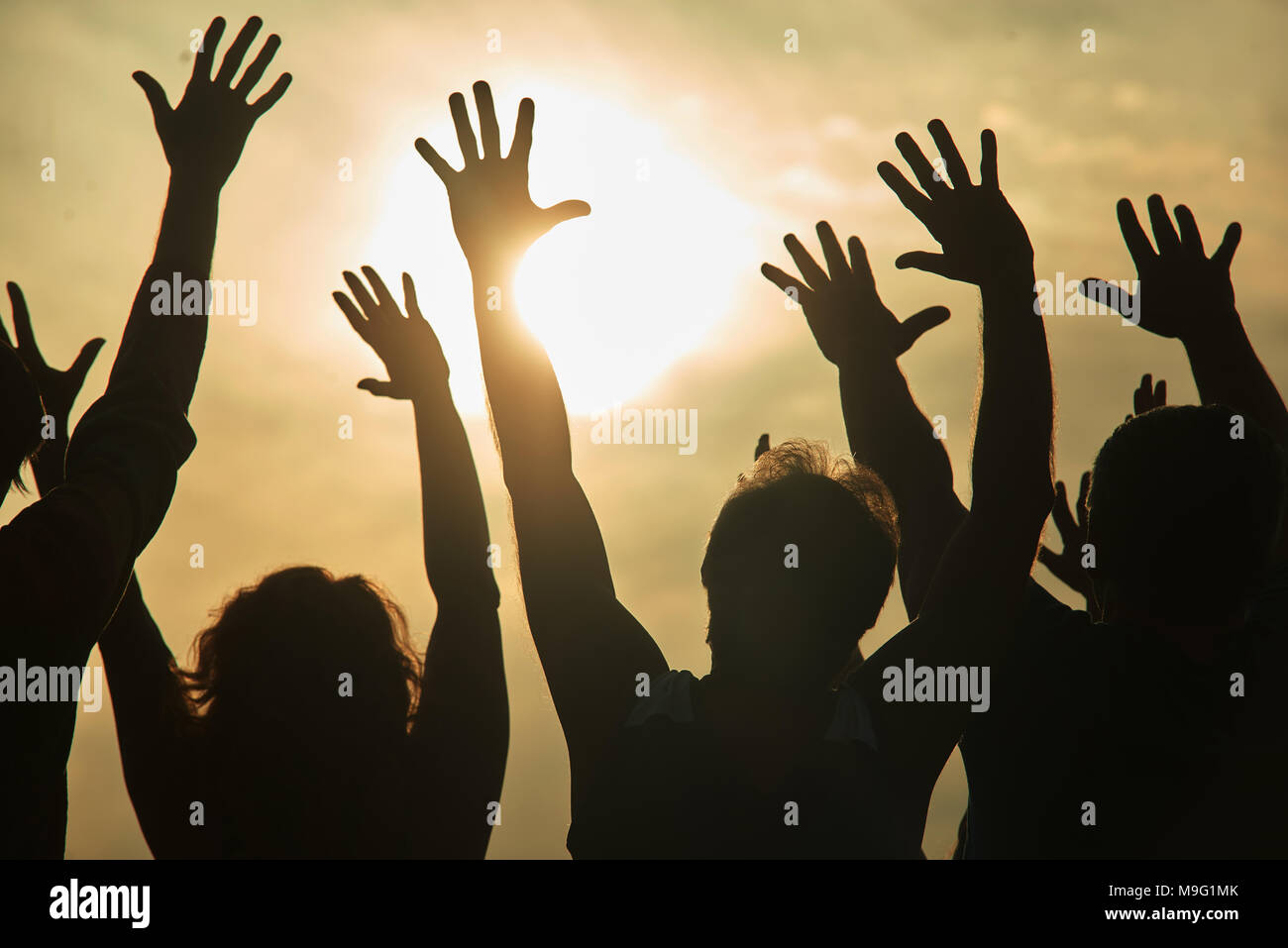 Dancing people at rock concert. Young people with hands up looking at ...
