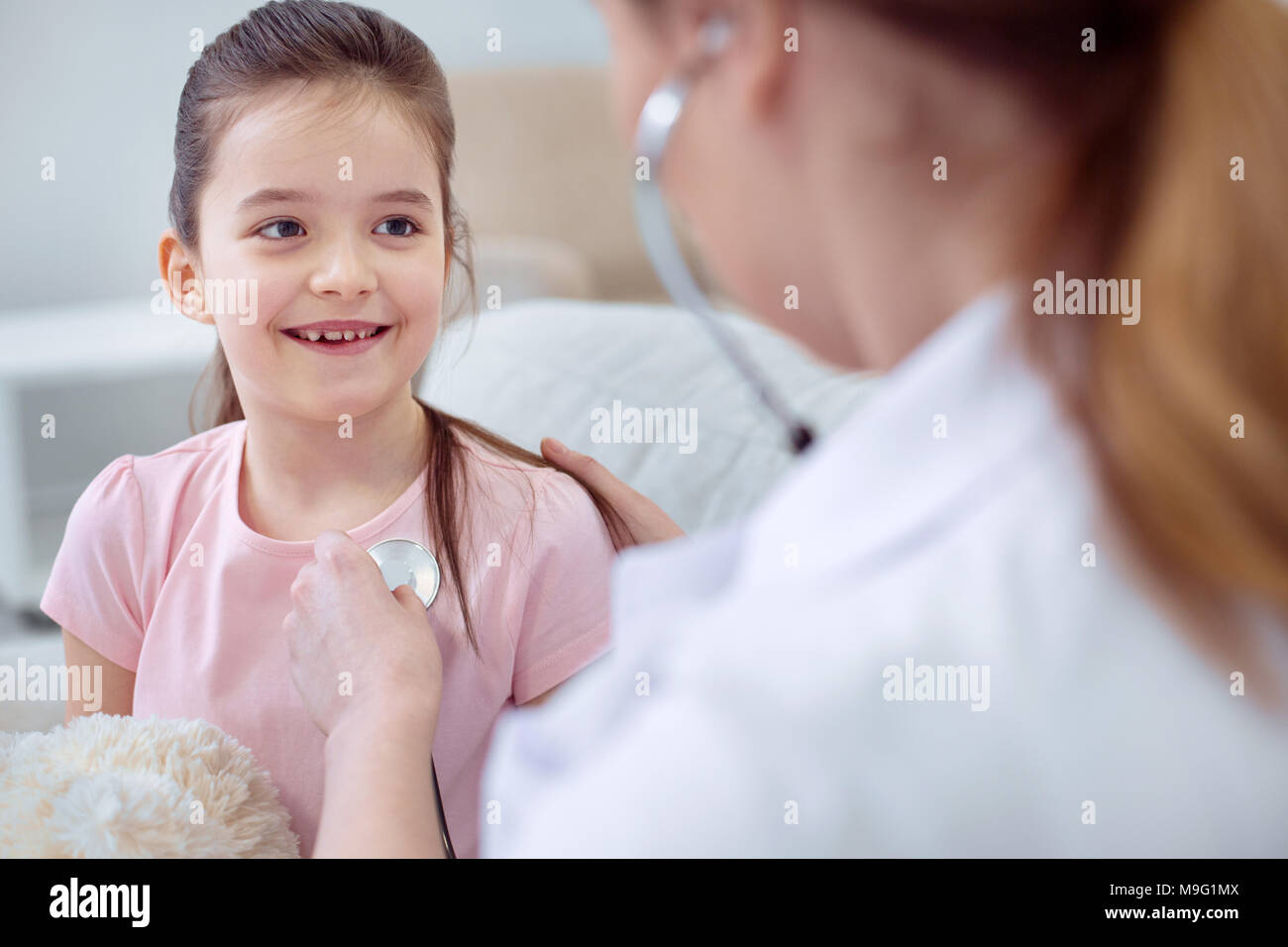 Charming girl breathing for female doctor Stock Photo - Alamy
