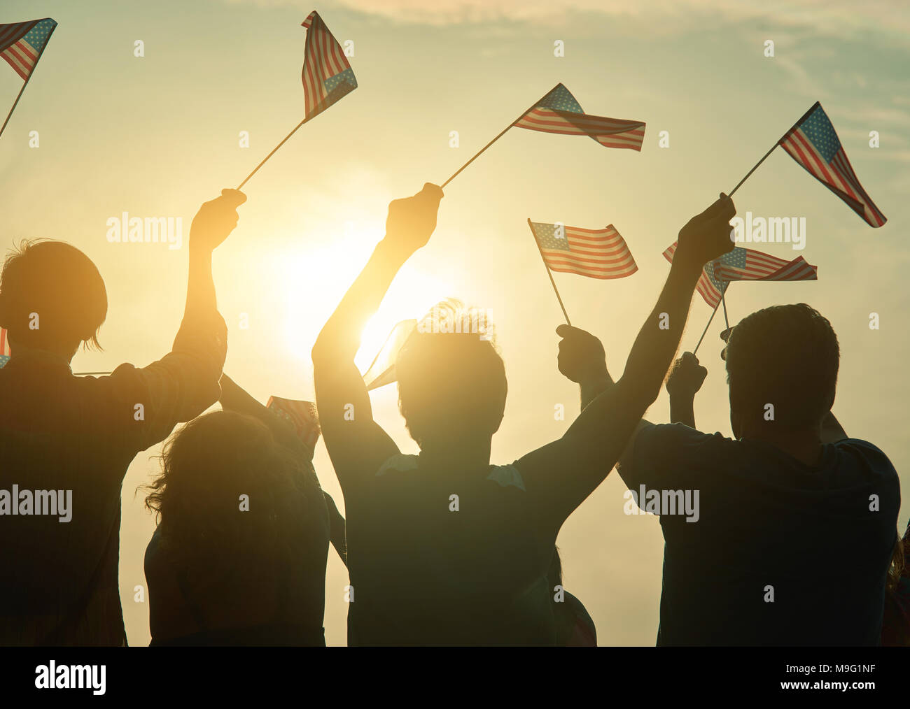 People raising USA flags in the air. Morning sunrise in the sky Stock ...