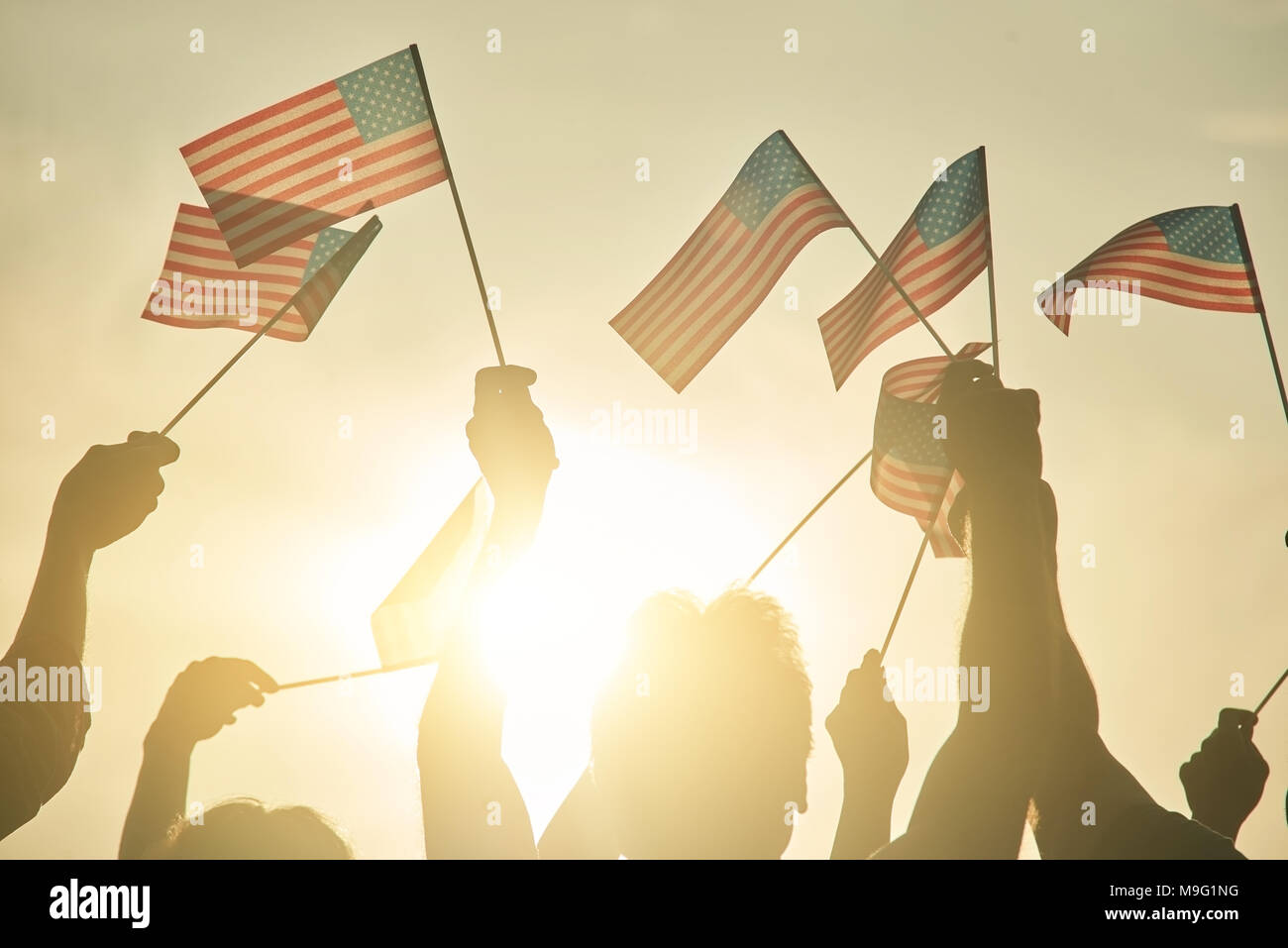 People hold up US flags during a rally in support. Patiotic people ...
