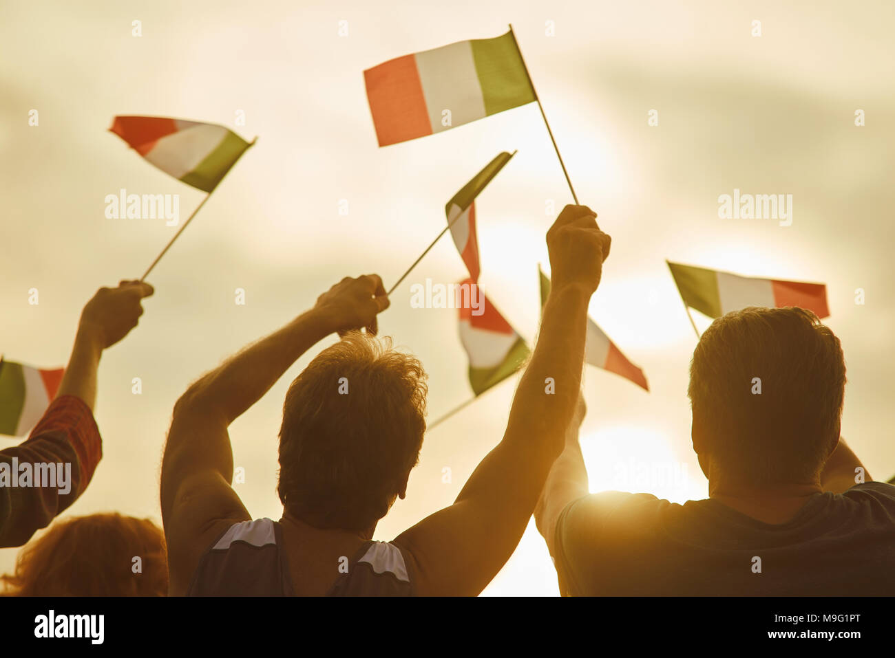 Young people waving italian flags, back view. Italian family against ...