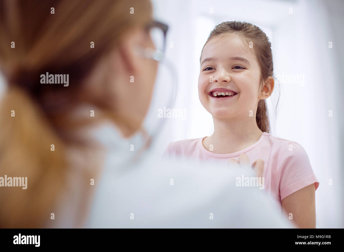 Joyful girl having fun while doctors examination Stock Photo - Alamy