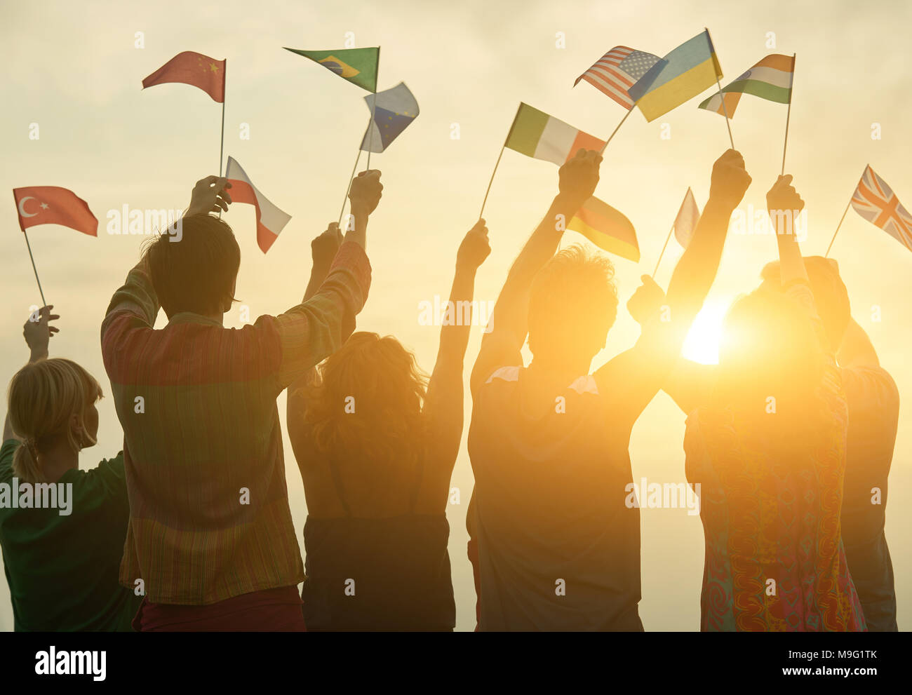People holding different flags. Back view. Sunny evening sky background ...