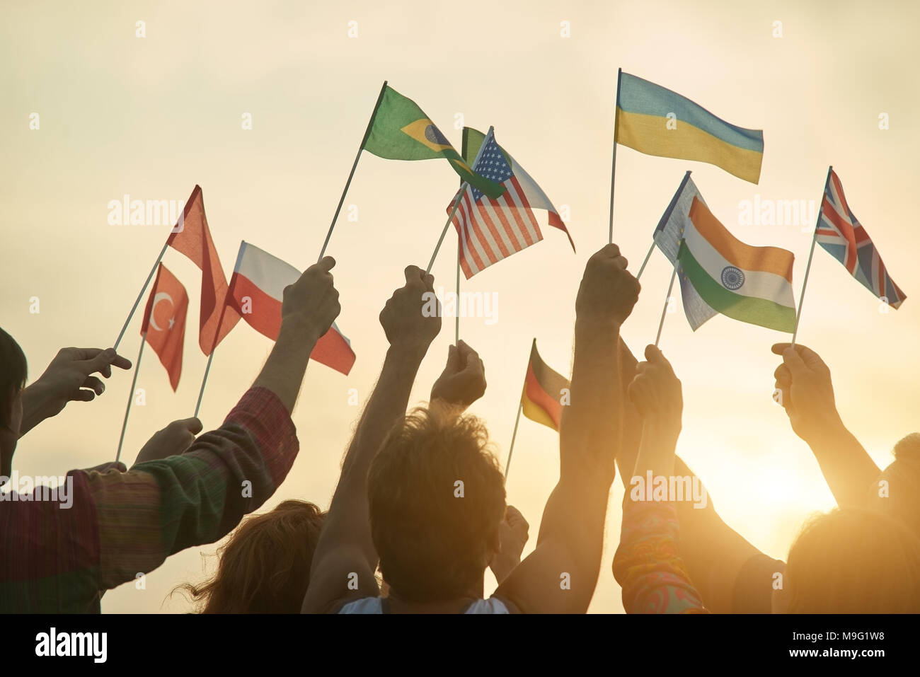 Group of people with various flags. Back view. Sunny evening sky ...