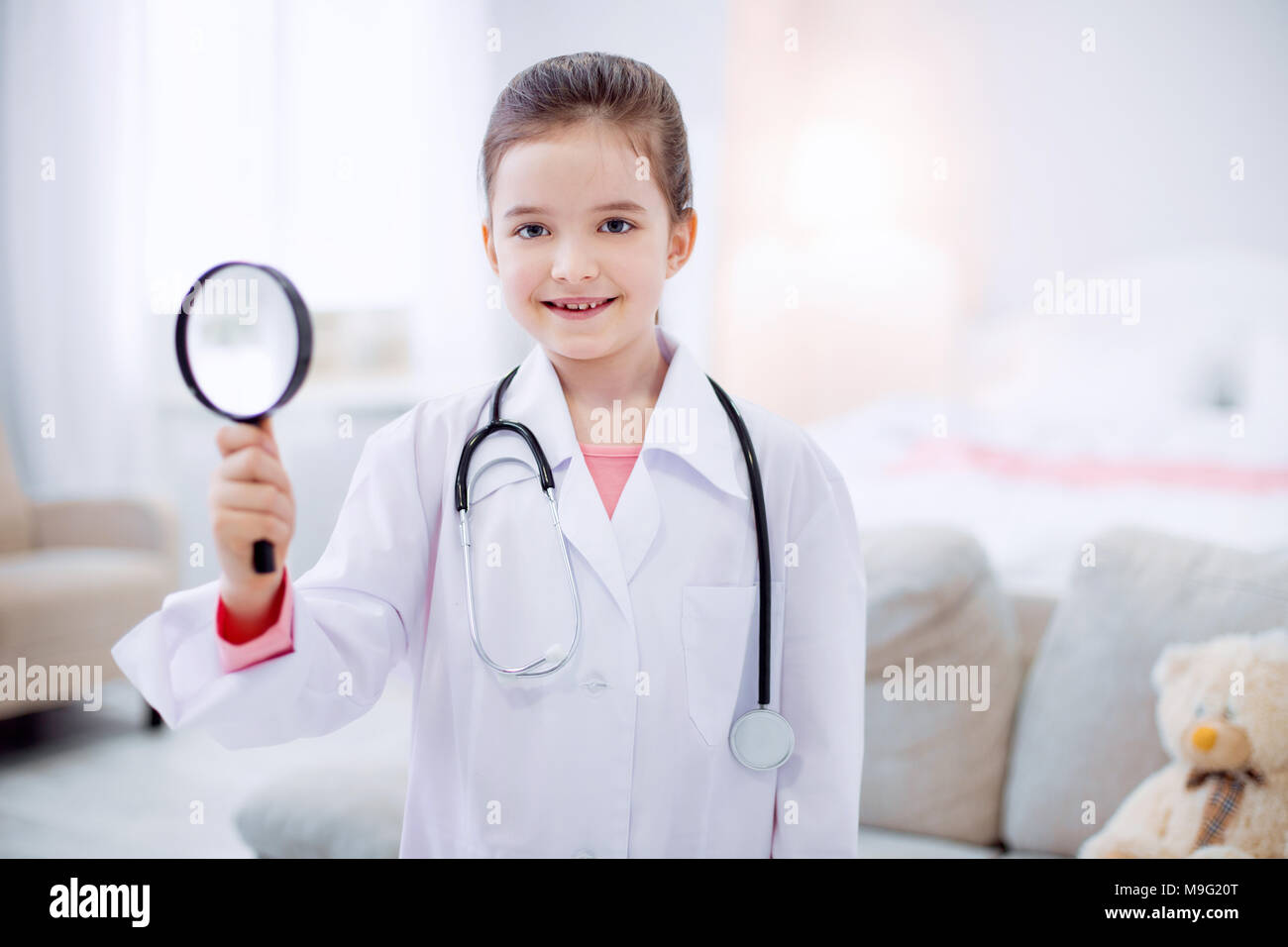 Happy merry girl standing with magnifying glass Stock Photo - Alamy