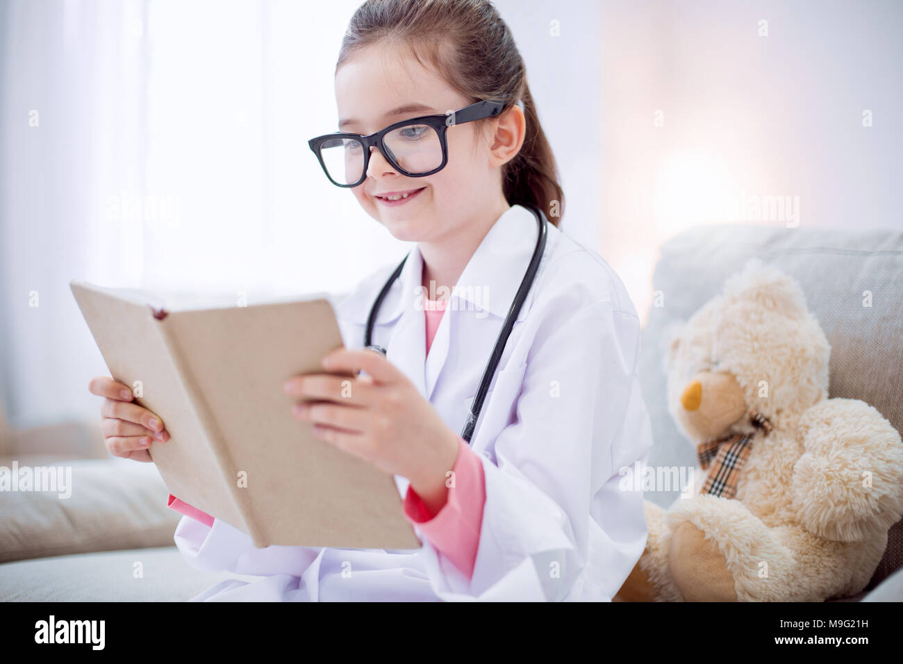 Smart ambitious girl reading book Stock Photo - Alamy