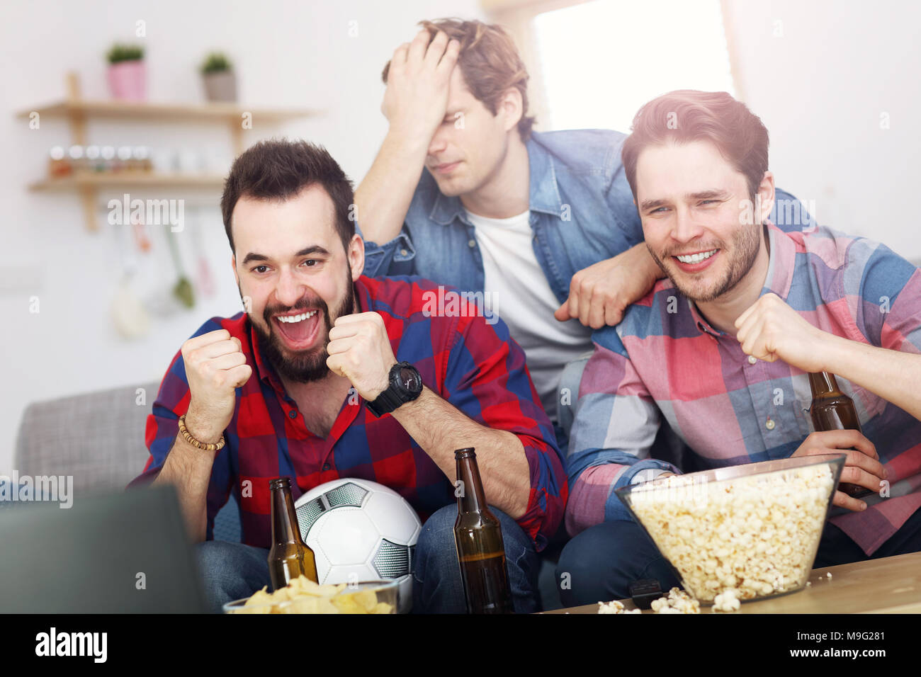 Picture of happy male friends cheering and watching sports on tv Stock ...