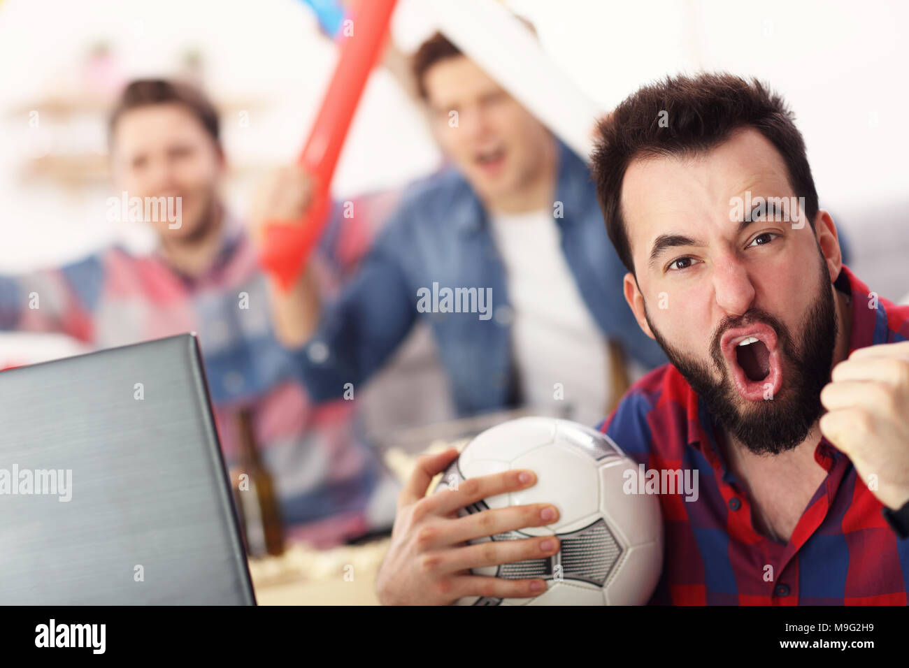 Picture of happy male friends cheering and watching sports on tv Stock ...
