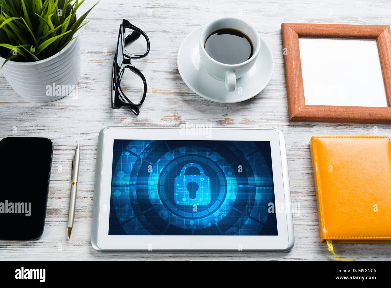 Business workplace with office stuff and tablet with padlock icons on ...