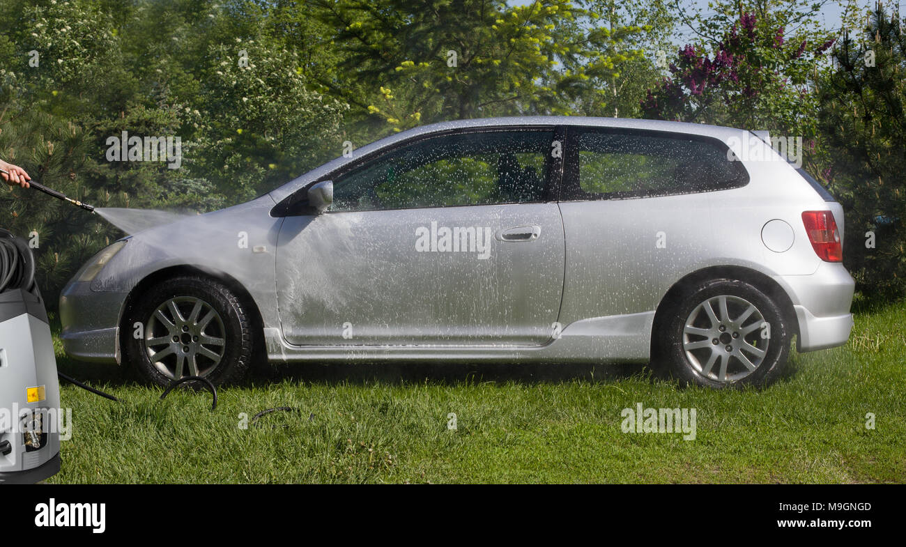 Washing car - pressure washer. Spring car washing outside, ecology ...