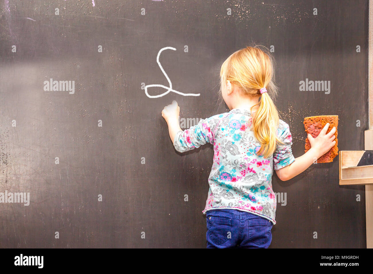 Cute little girl writing Pound sign on chalkboard in a classroom Stock ...