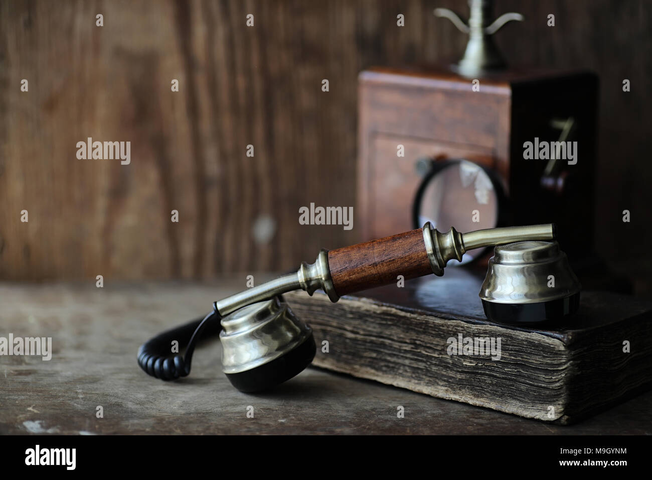 Old telephone and retro book on a wood Stock Photo - Alamy
