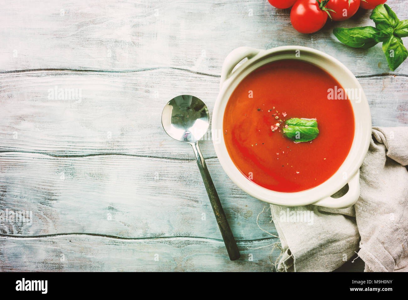 Tomato soup in a white bowl on wooden table, top view Stock Photo - Alamy