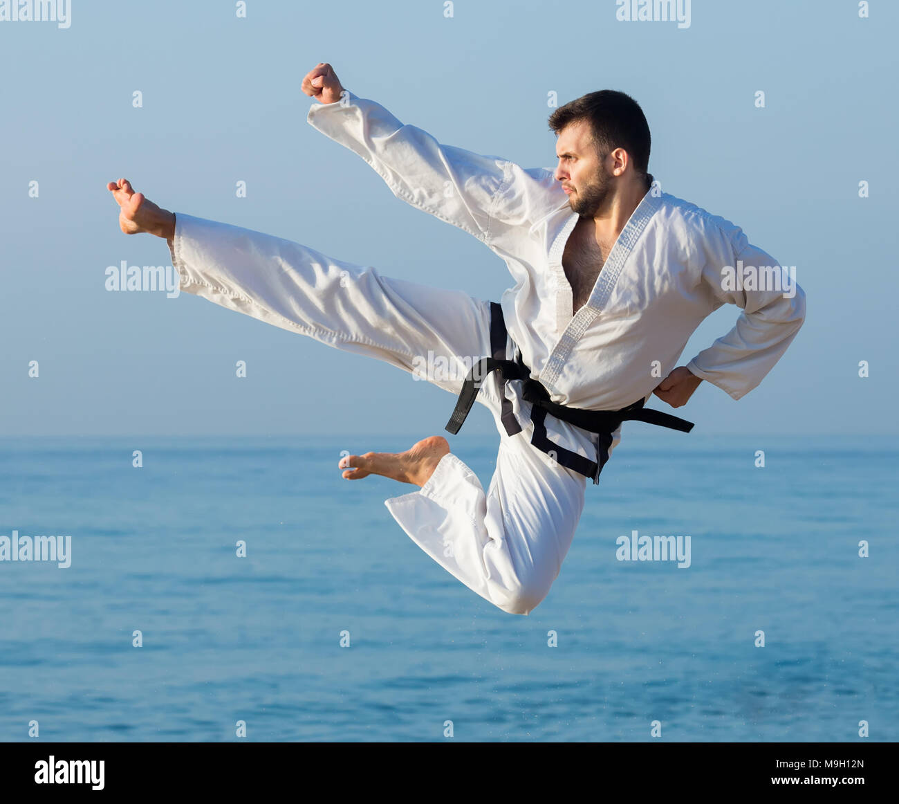Young man shows his skills in karate on the sea beach Stock Photo - Alamy