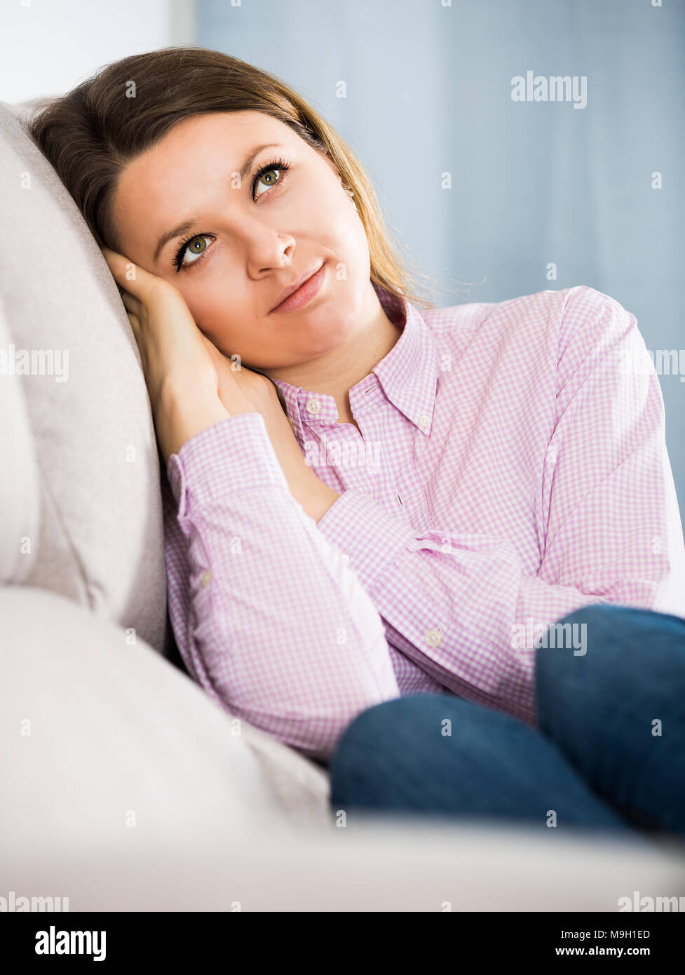 Young female is feeling distressed and lonely alone at home Stock Photo ...