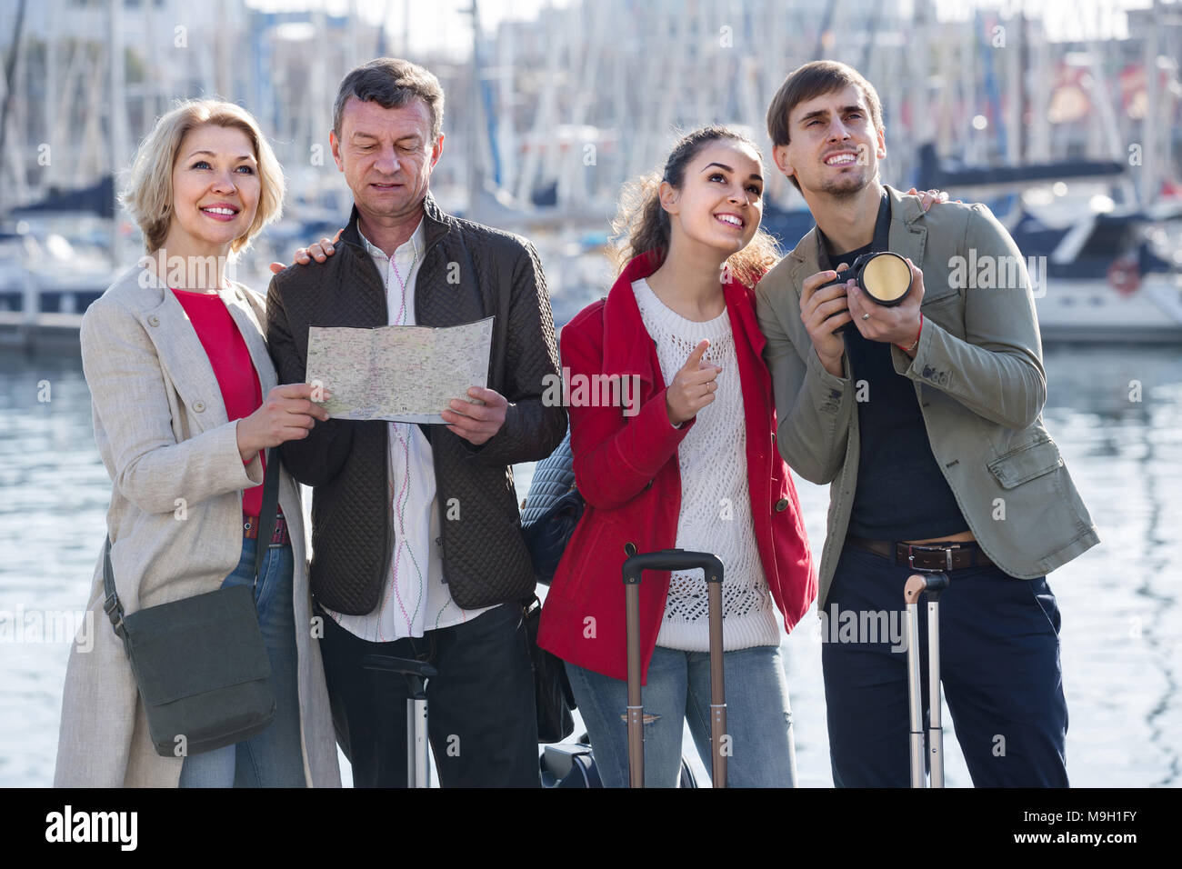 Portrait of happy tourists with map and baggage seeing the sights in ...