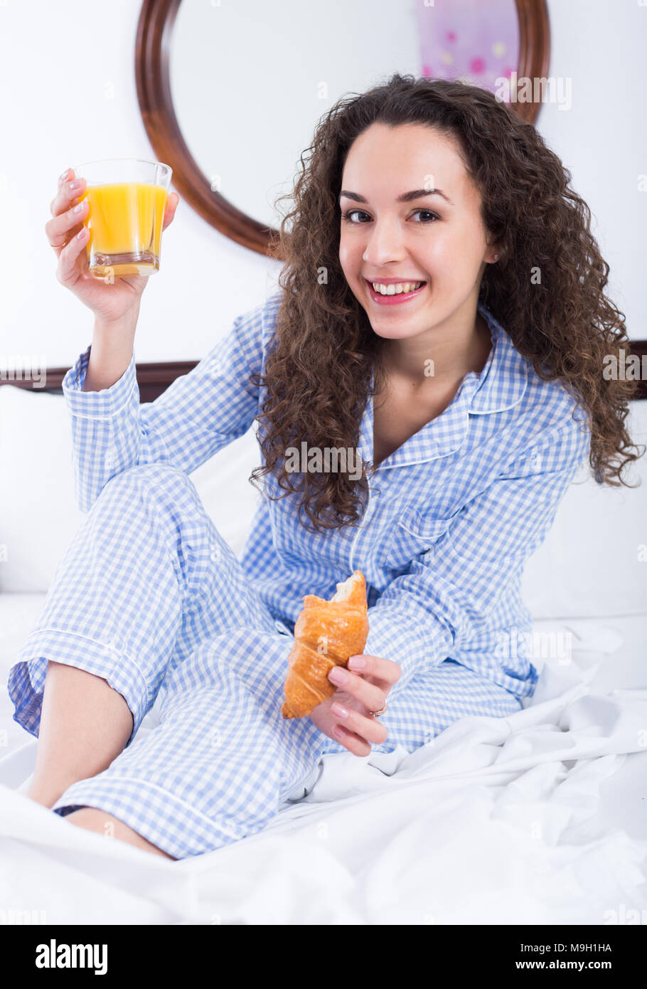 Adult female enjoying breakfast with fresh pastry in bed Stock Photo ...