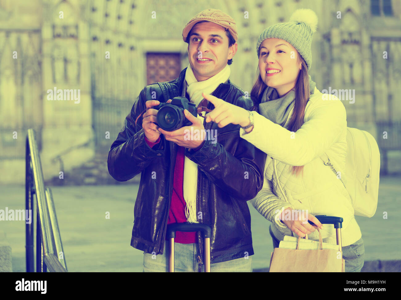 happy atractive male and female in the historic center pointing finger ...