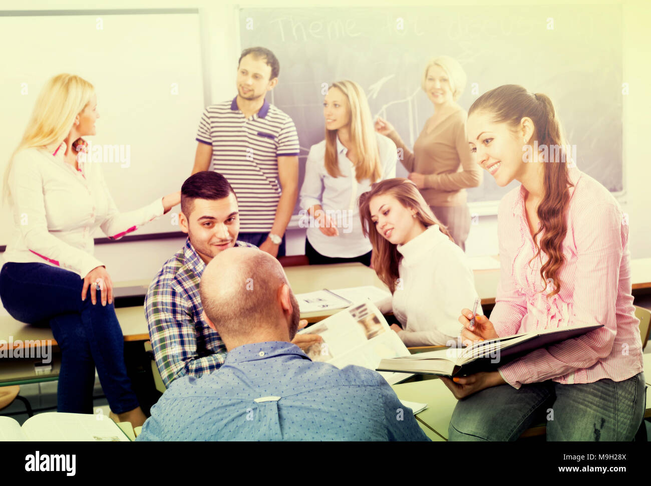 Teacher explaining interesting topic to curious students during a break ...
