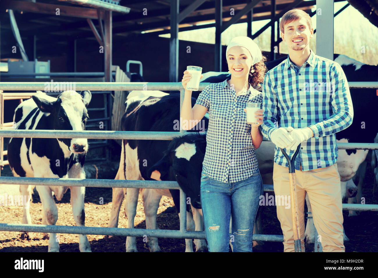 Portrait of two young cheerful positive farm workers holding glass with ...