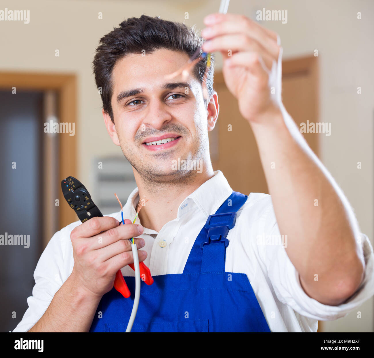 Young professional fixing indoor wiring in new building Stock Photo - Alamy