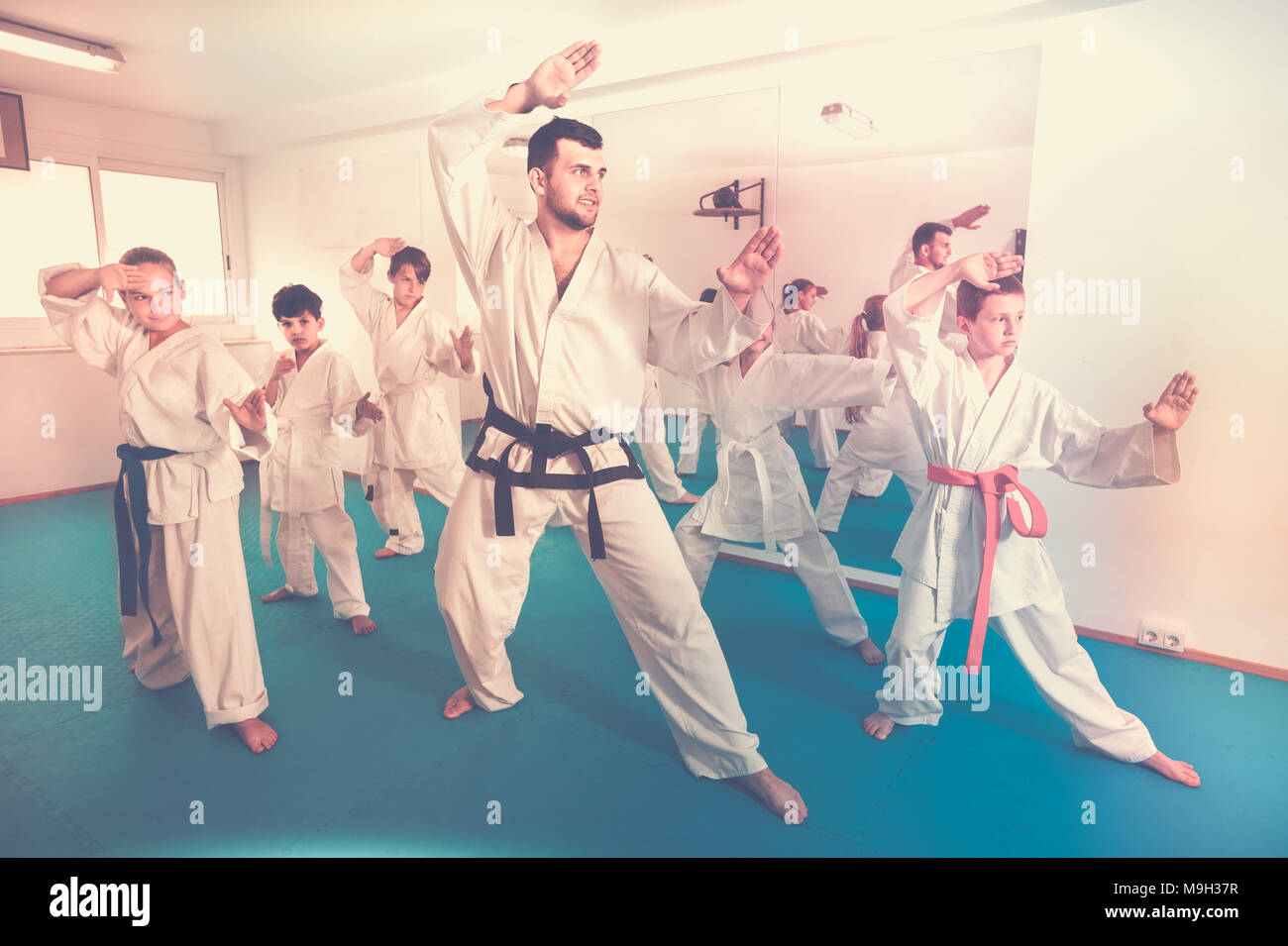 Children trying new martial moves in practice during karate class in ...
