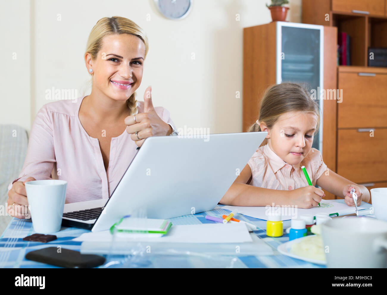 happy european businesswoman browsing internet at home, daughter ...