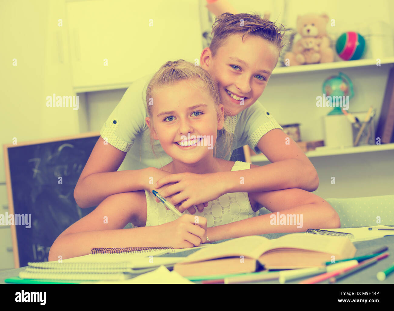 Brother is helping sister with homework at home Stock Photo - Alamy