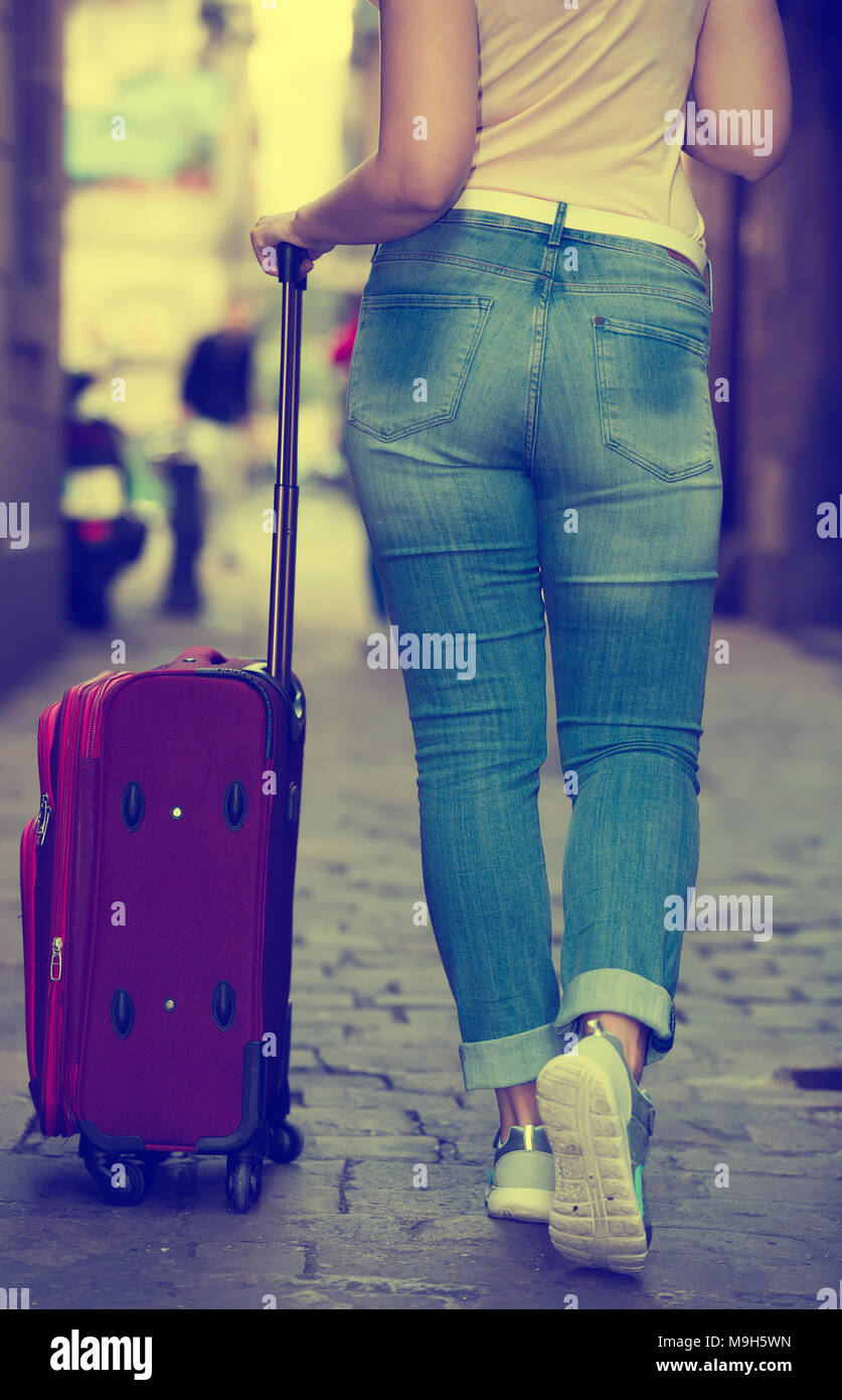 tourist blond girl going a walk in the town with the travel bag Stock ...
