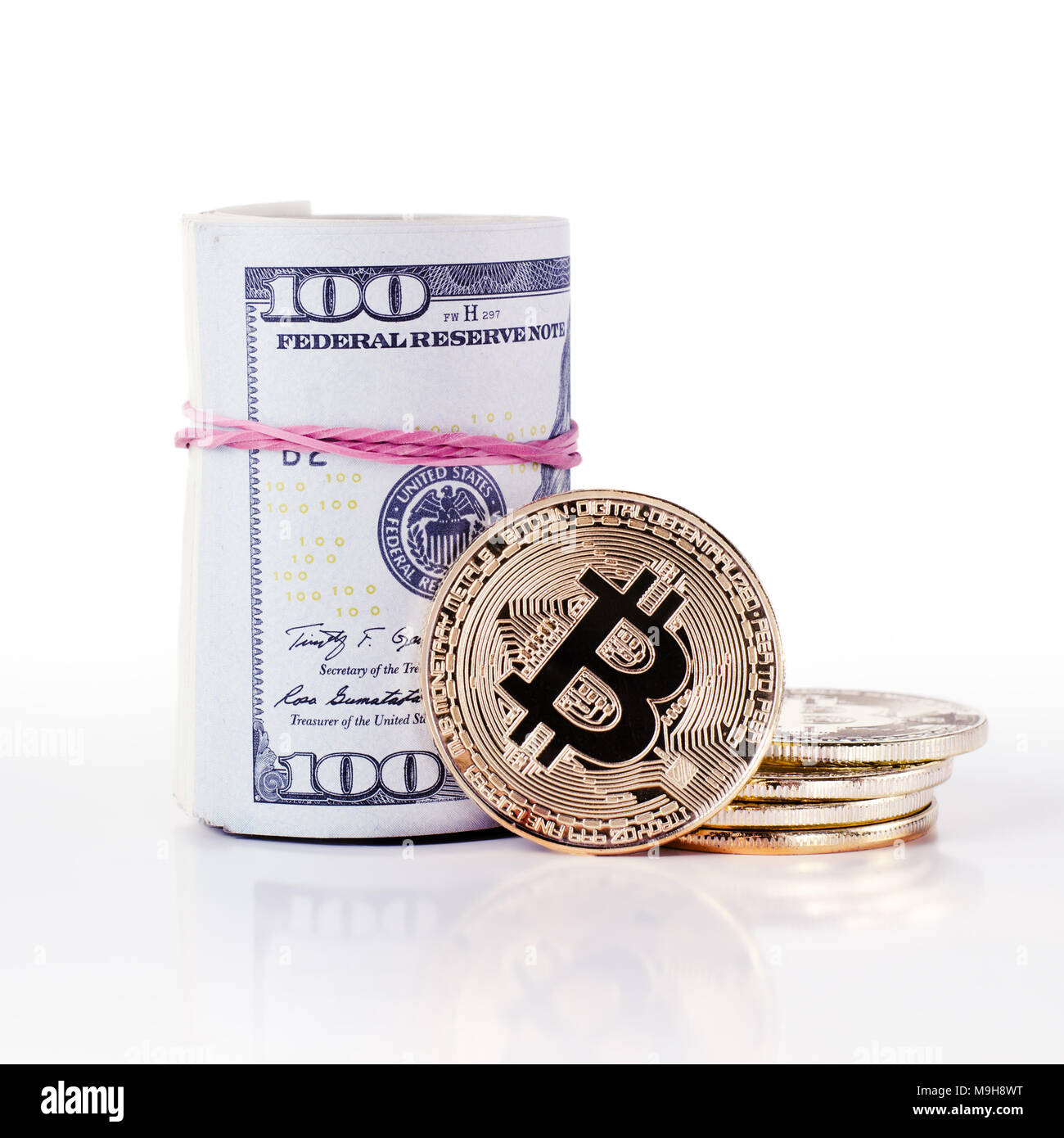 Physical Gold Bitcoin Coin and dollar bill roll on a white background ...