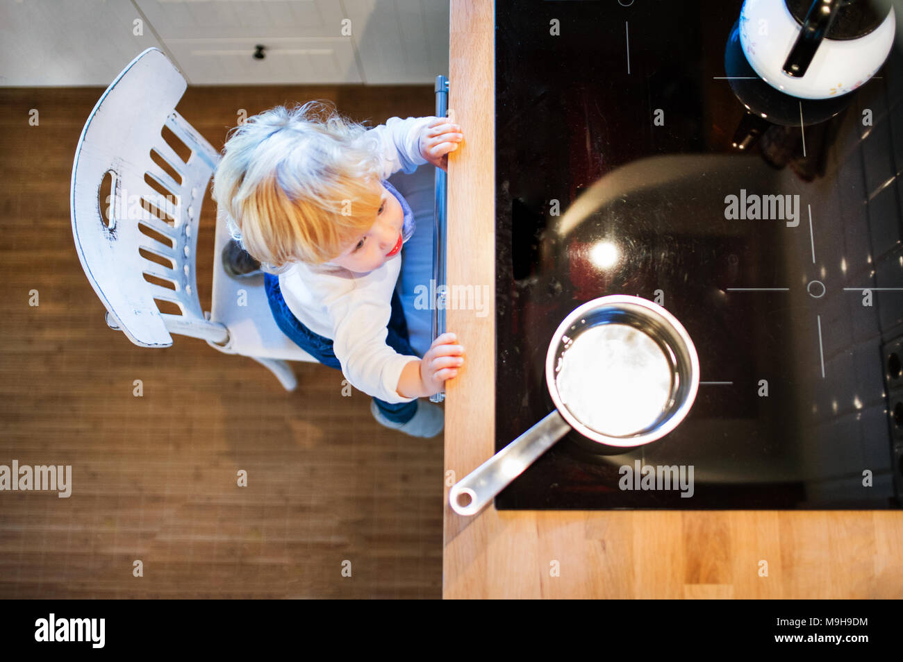 Toddler boy in a dangerous situation at home. Domestic accident. Child ...