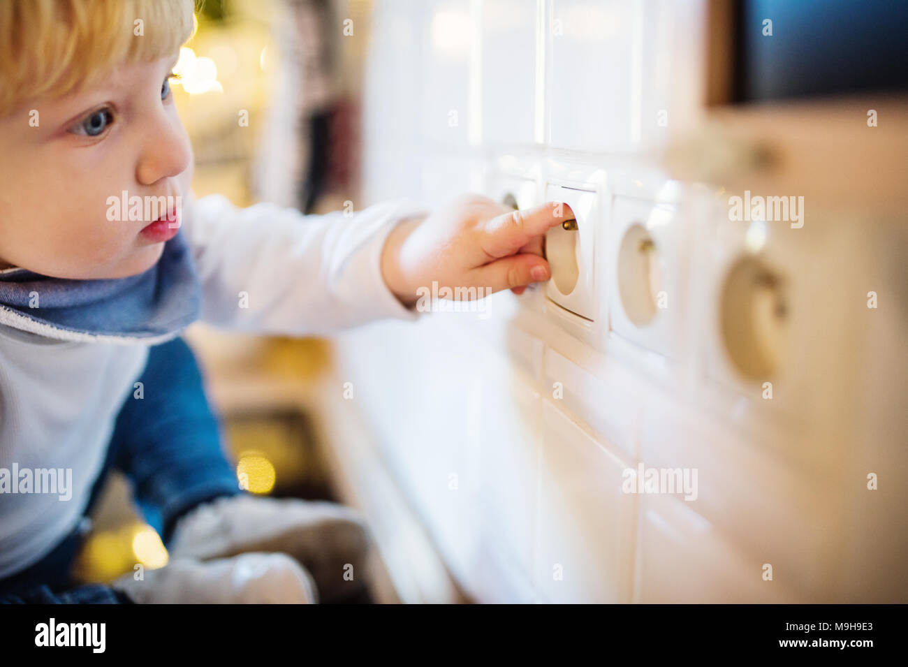Little toddler putting fingers in a power socket. Domestic accident ...
